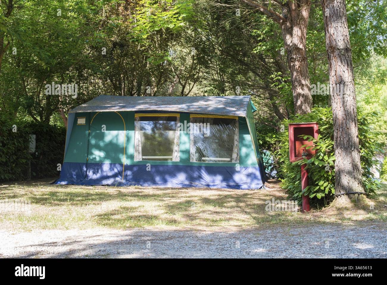 Tent on campsite between the trees. Sun light Stock Photo - Alamy