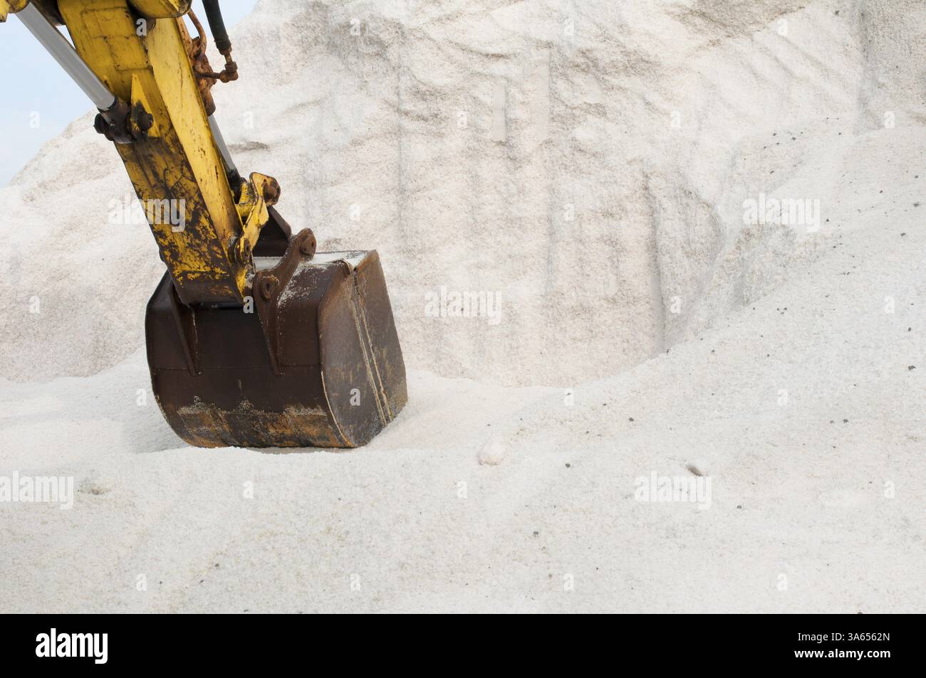 Excavator digging pile white salt Stock Photo - Alamy