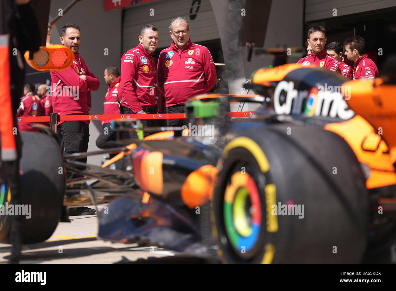 The members of Ferrari team watch McLaren's "champion" racing car ...