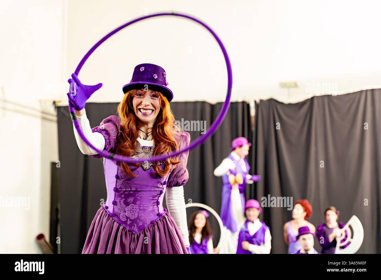 Redhead woman wearing purple costume and holding hula hoop, smiling ...
