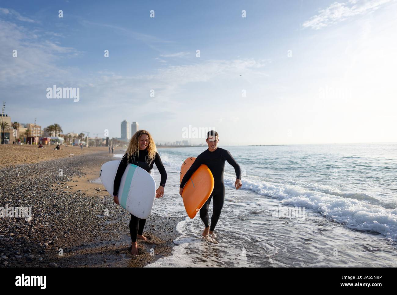 Beautiful happy surfer couple having fun on the beach, running with ...