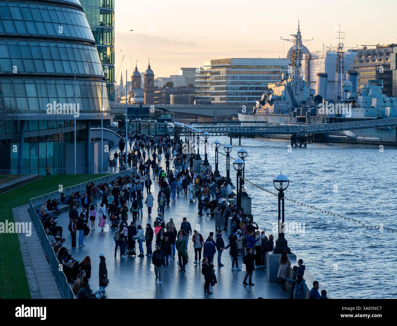 People walking next to the River Thames as evening falls, The Queen's ...