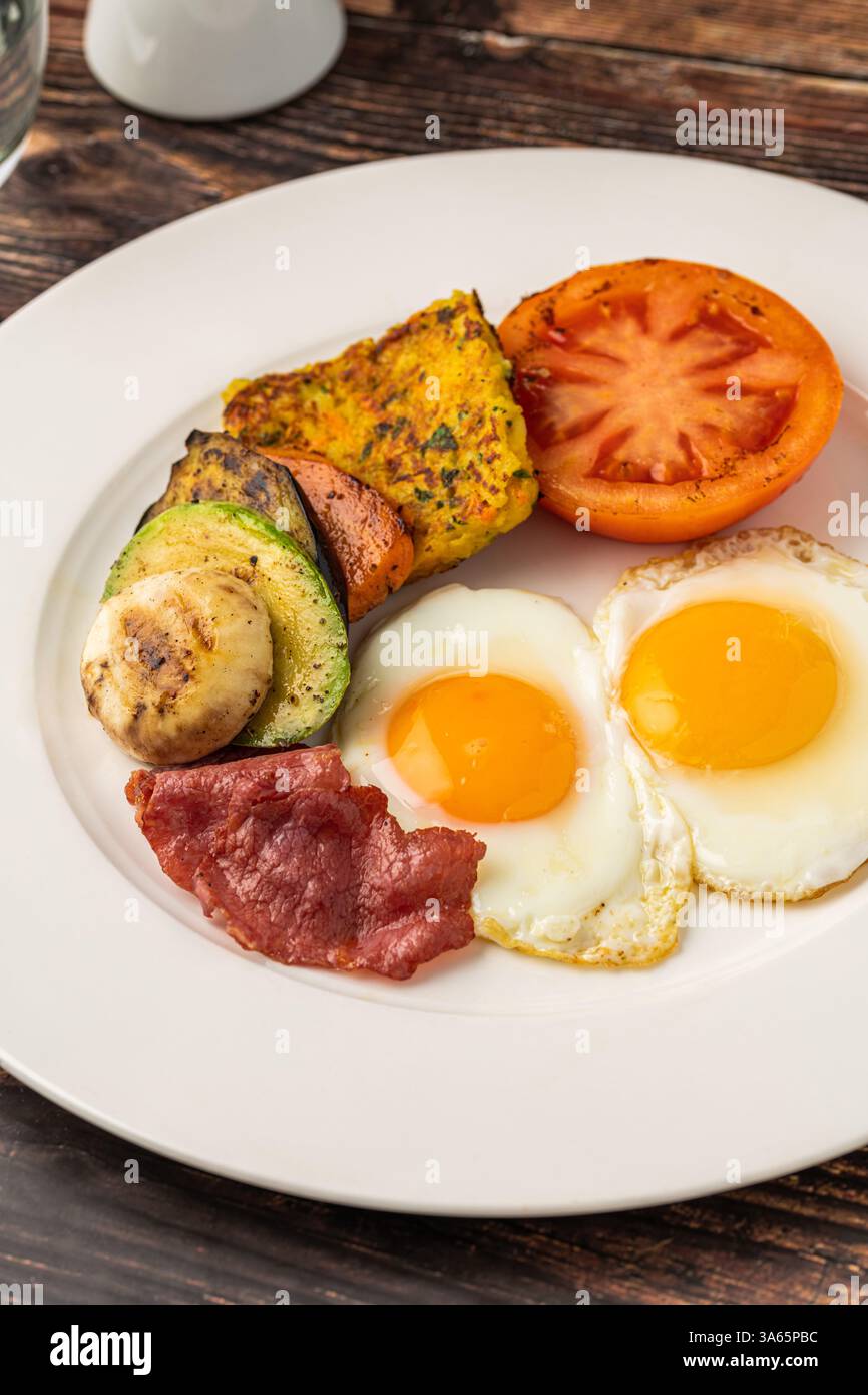 Rustic breakfast plate with fried eggs, grilled vegetables, and turkey ...