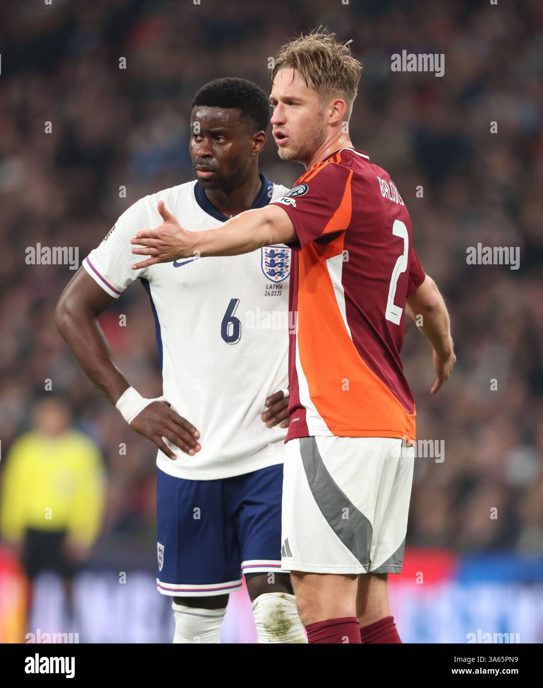 London, UK. 24th Mar, 2025. Mark Guehi (E) Daniels Balodis (L) at the ...