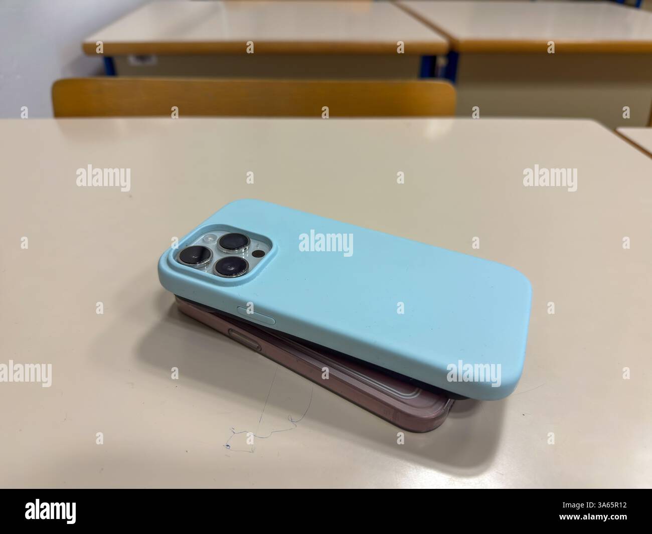 Smartphones Stacked on Desk in Classroom Representing Phone Ban Policy ...