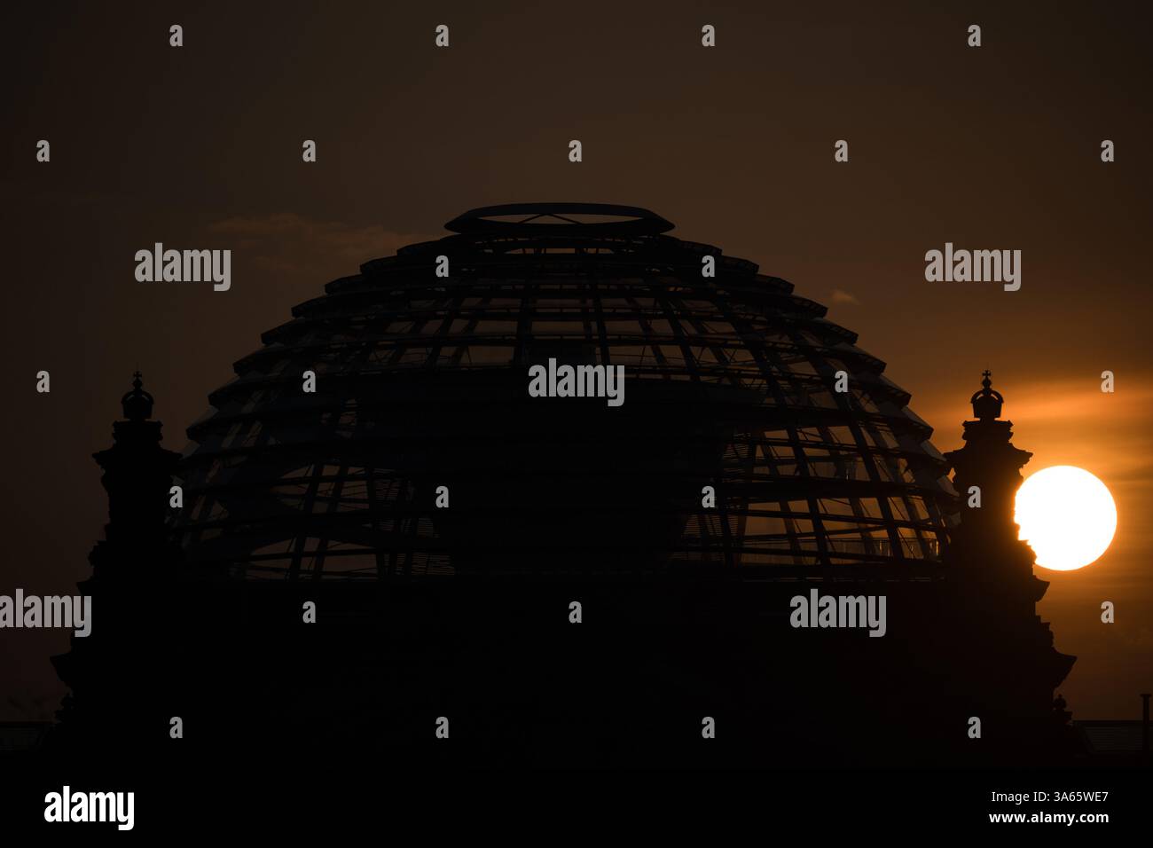 Berlin, Germany. 25th Mar, 2025. The sun rises behind the Reichstag on ...