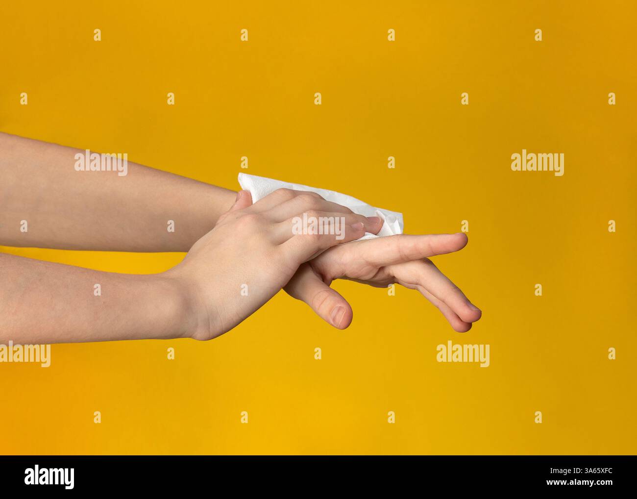 Person is cleaning their hand with antiseptic wipe against yellow ...