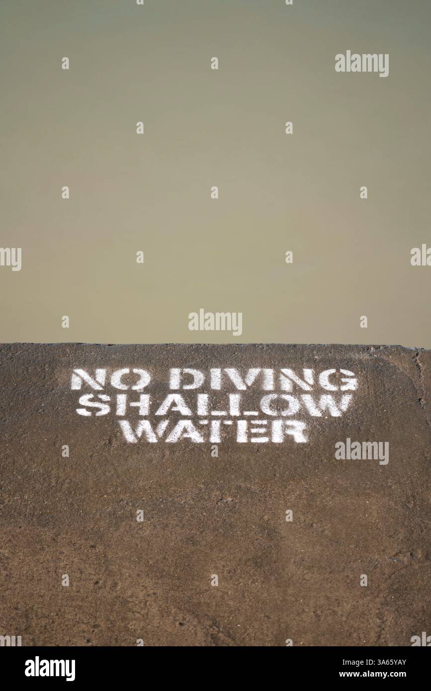 A NO DIVING SHALLOW WATER painted sign at the marine lake in Weston ...