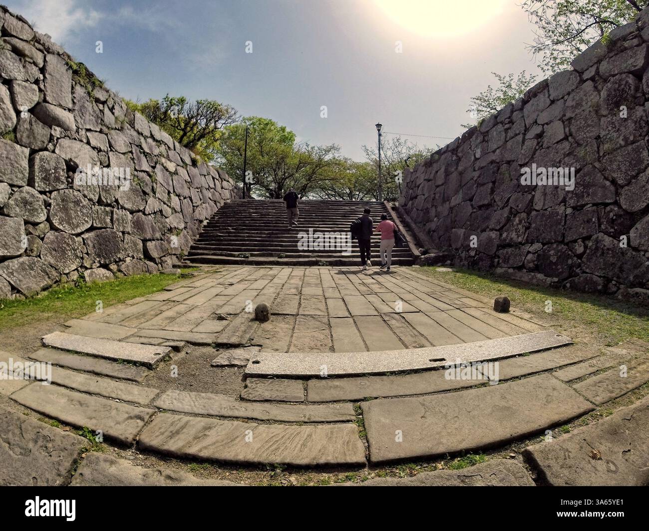 A walking path within Maizuru Park, amid ruins and old stone ...