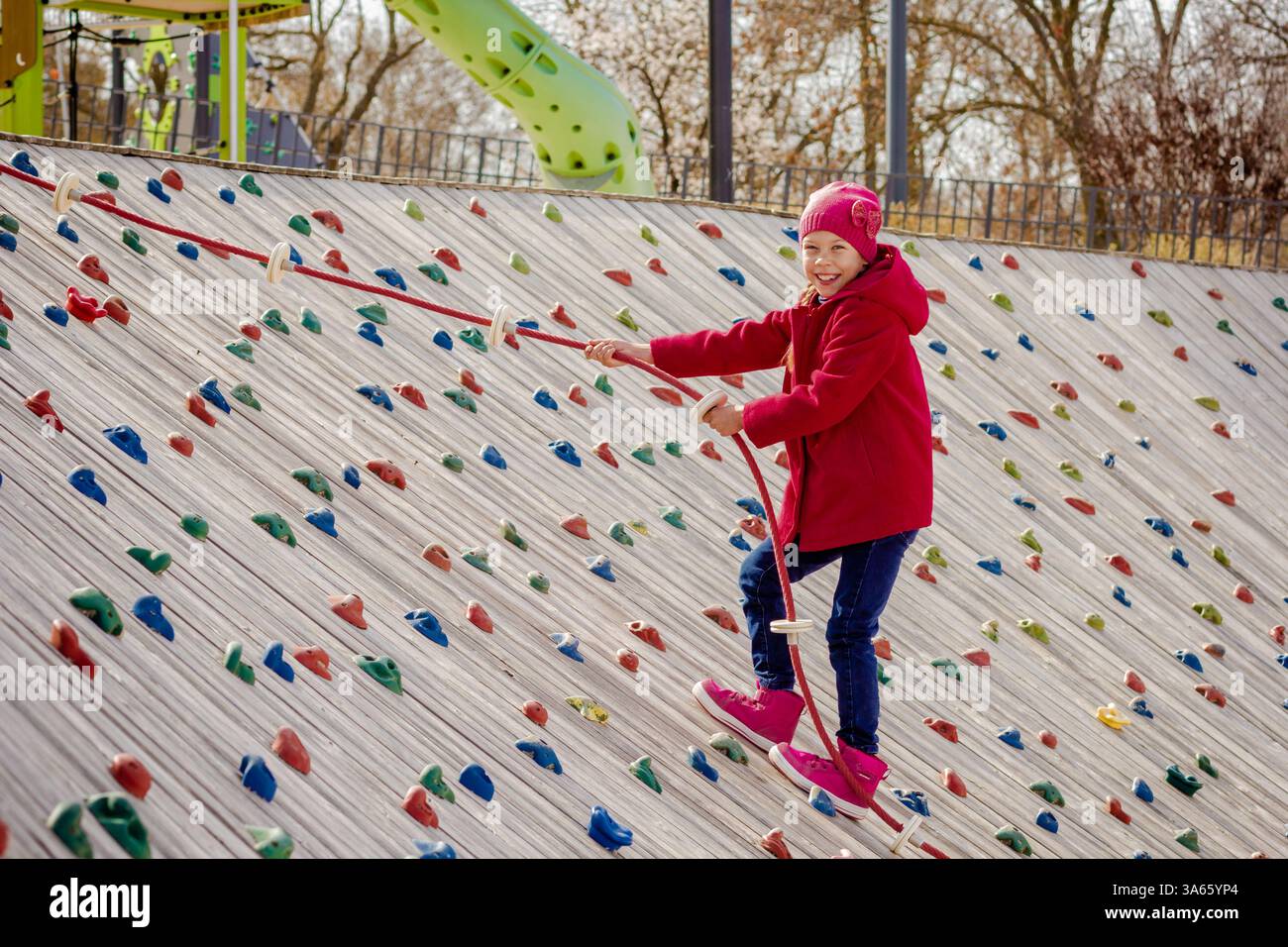 Happy child climbing on artificial rock wall on playground Stock Photo ...