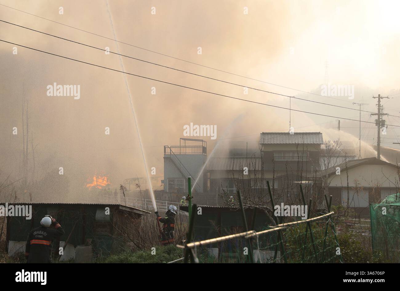 Firefighters struggle to extinguish the fire triggered by a wildfire in ...