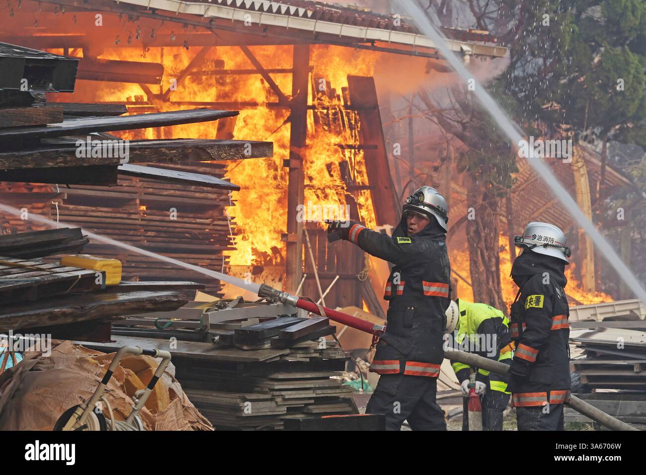 Firefighters struggle to extinguish the fire triggered by a wildfire in ...