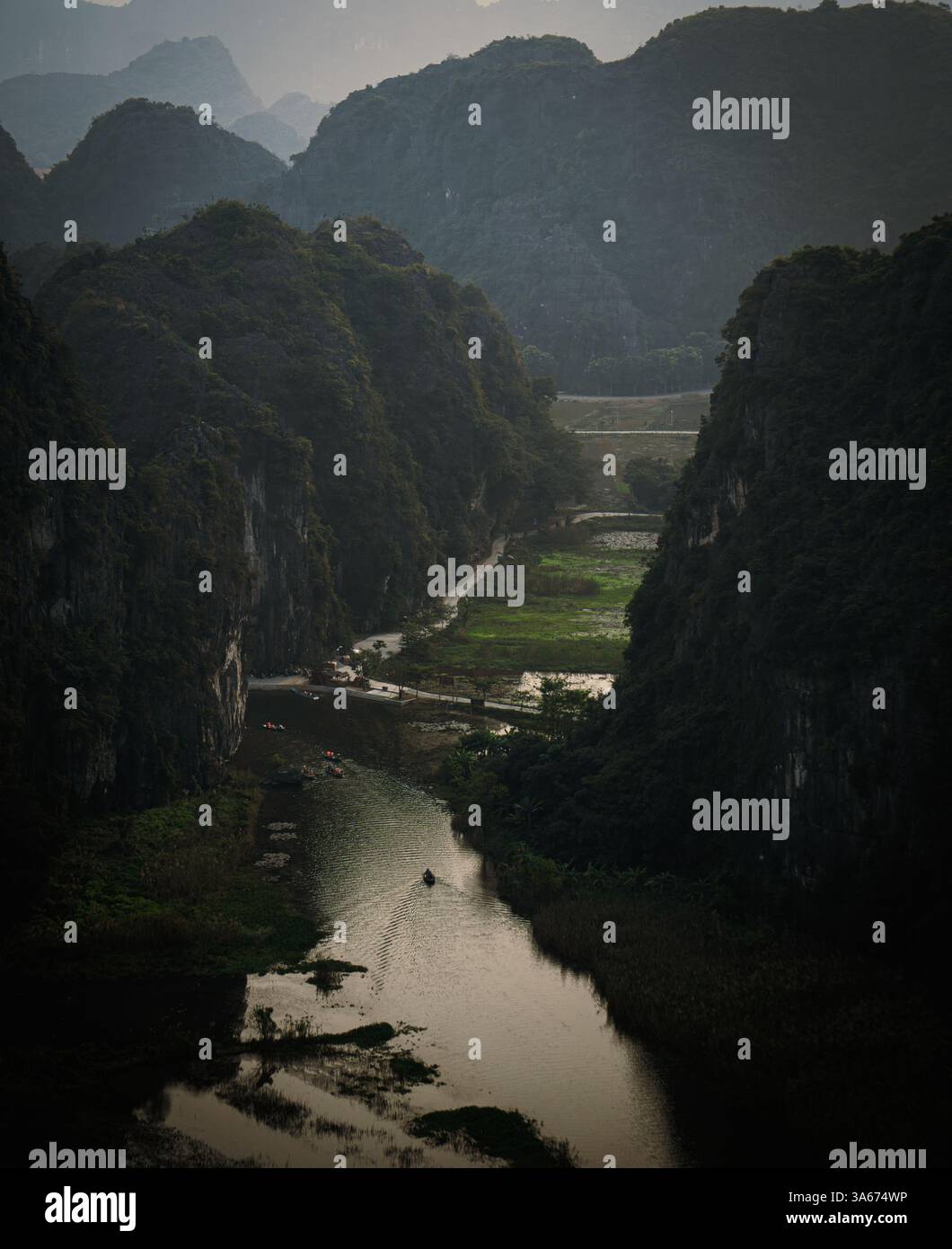 Misty mountain valley covered in green vegetation and Ngo Dong River viewed from Hang Mua ...