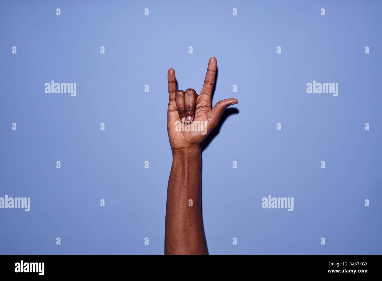 Close-up of a raised hand showing rock and roll gesture with fingers ...