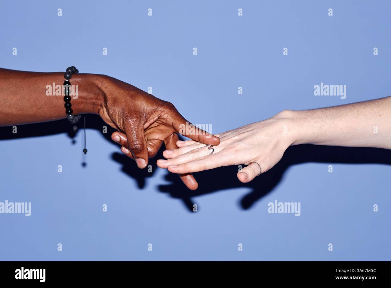 Close-up image showing two hands from different racial backgrounds ...