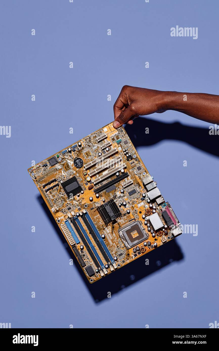 Hand Causian person holding seasoned computer motherboard against a ...