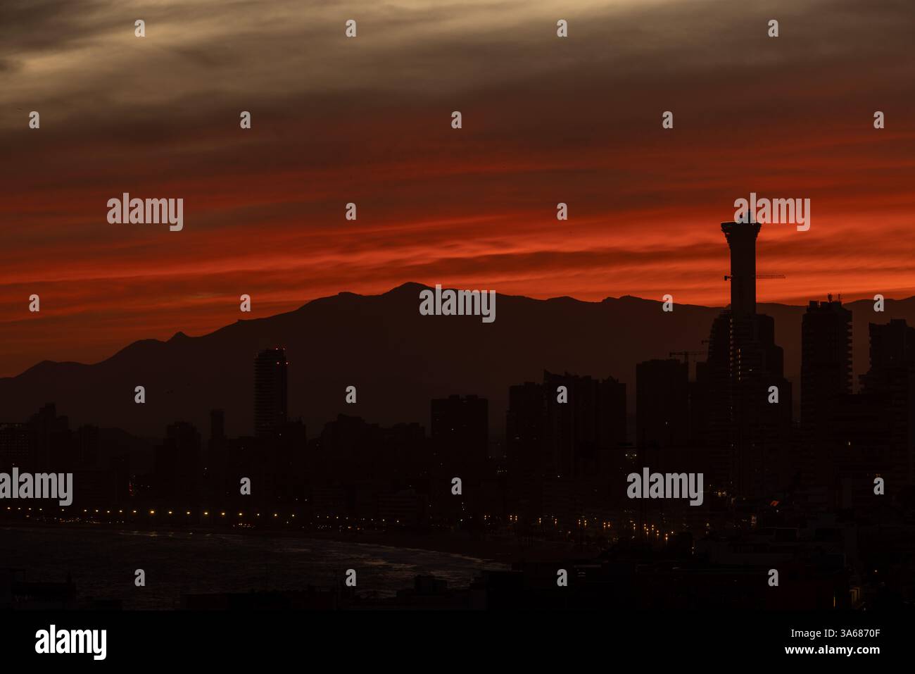 Photo of the sun setting in the evening over the old town of Benidorm ...