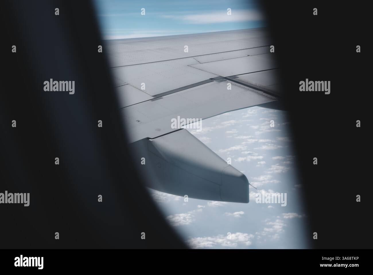 A breathtaking airplane wing view high above the beautiful clouds in ...