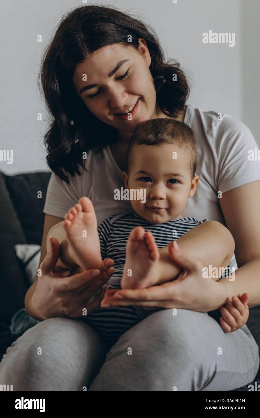 Two year old cute boy sitting in his mother arms,both smiling and ...