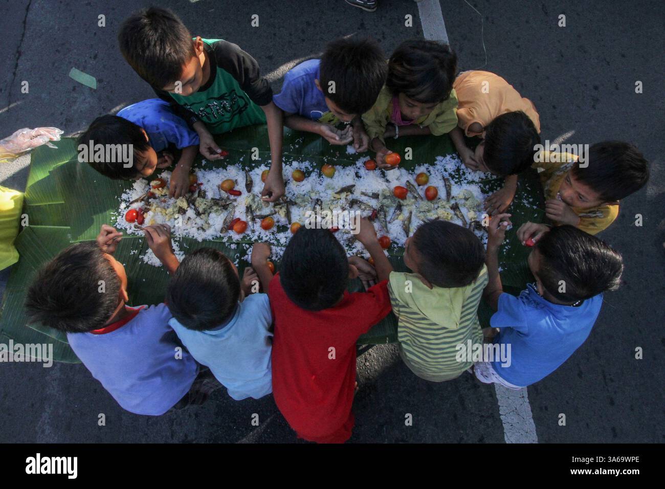 Nov. 23, 2014 - Quezon City, Philippines - Filipino children eat their ...