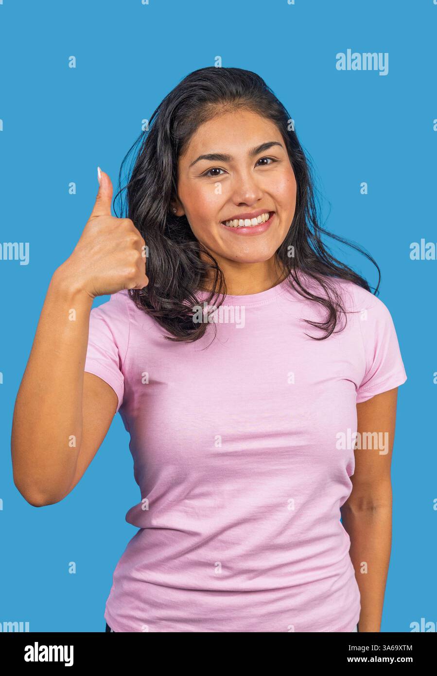 Happy young woman gesturing thumbs up, showing approval and agreement ...