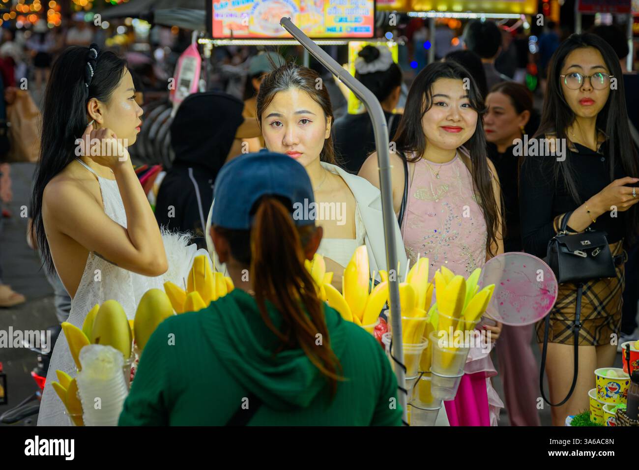 Ladies buying fresh fruit from a street seller at night in the ancient ...