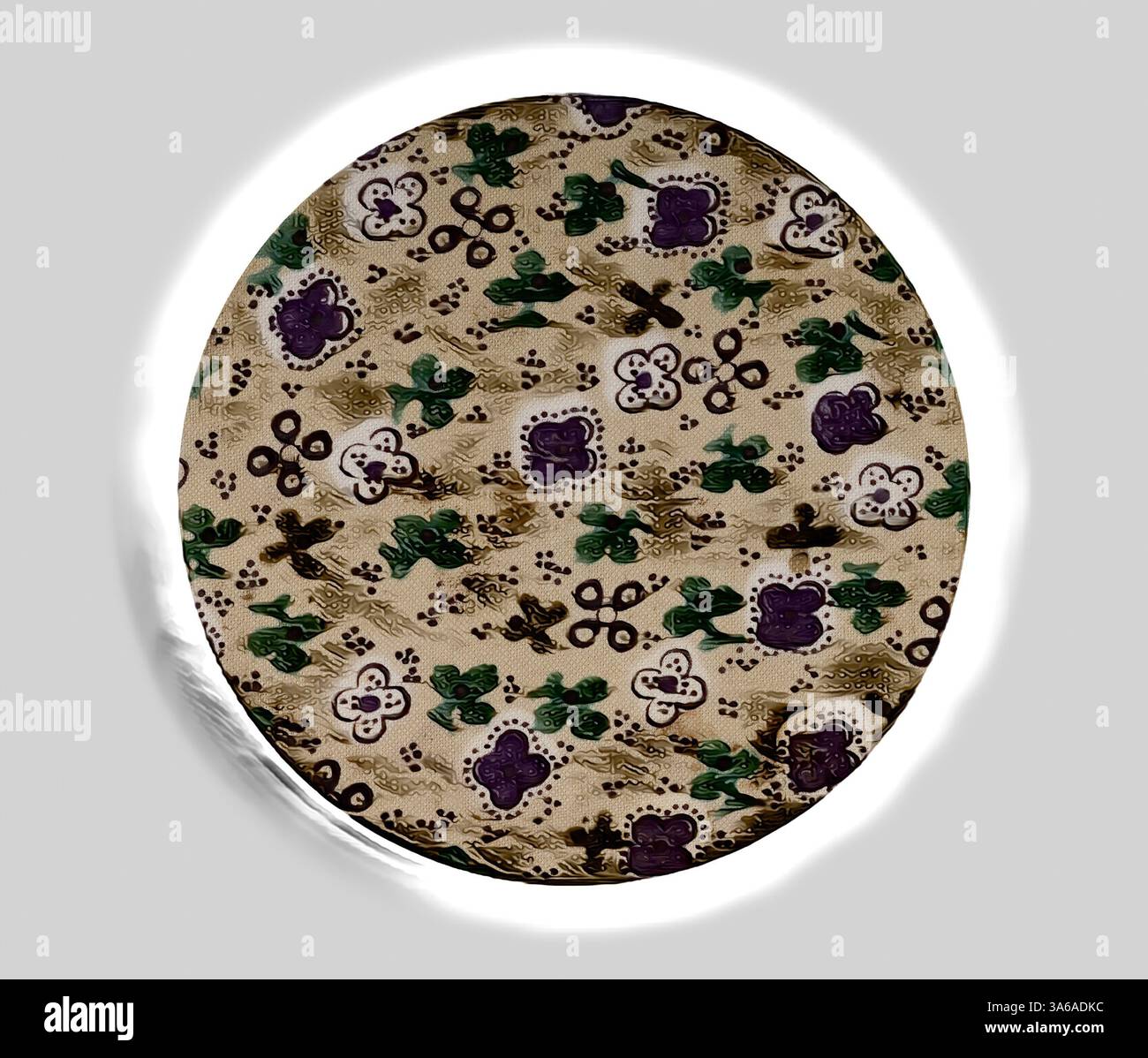 A round fabric displays an intricate pattern of flowers and leaves in ...