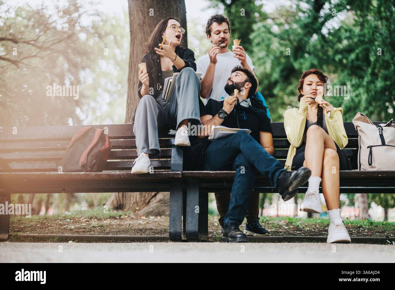 Students and professor enjoying ice cream break on park bench Stock ...