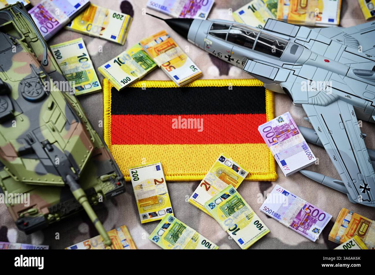 Deutschlandfahne mit Geldscheinen, Panzer und Militärjet, Symbolfoto ...