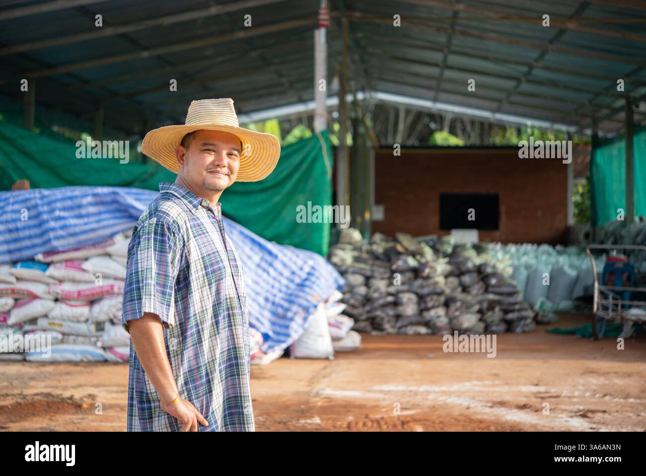 Asian man farmer agriculturist happy at a Fertilizer composting plant ...