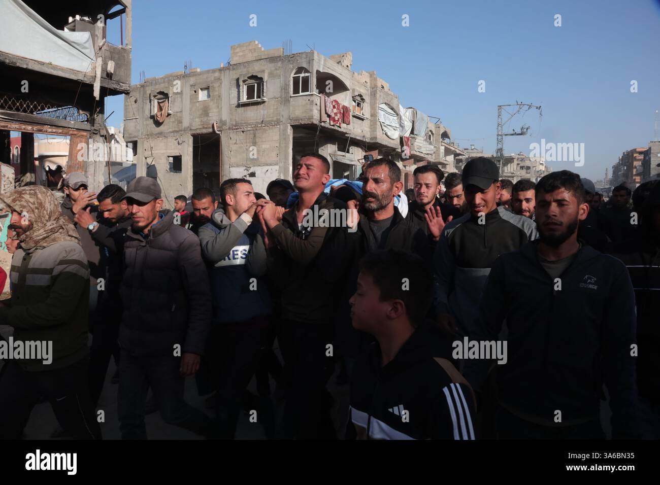 (250325) -- GAZA, March 25, 2025 (Xinhua) -- People carry the body of ...