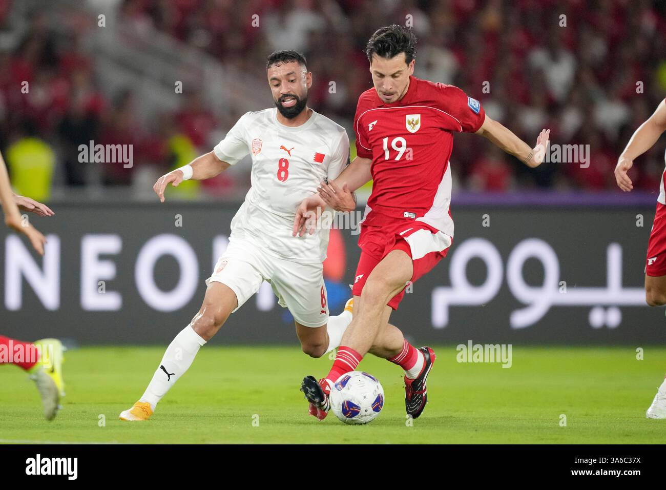 Bahrain's Mohamed Marhoon, left, battles for the ball against Indonesia ...