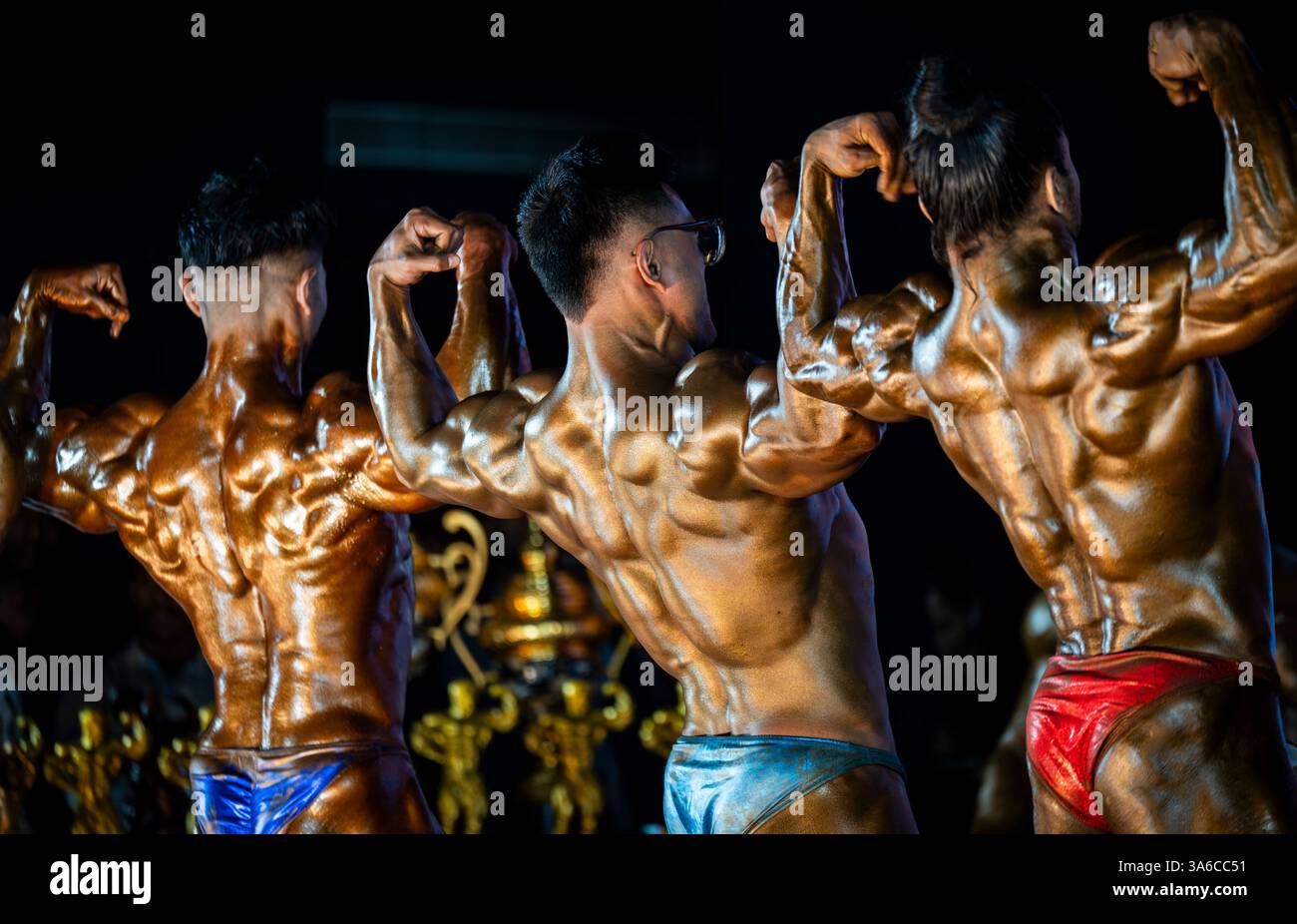 Male bodybuilding competitors flex their muscles as they compete during ...