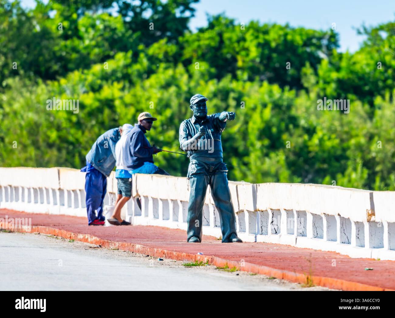 Local people fishing on a bridge, next to the bronze statue of Ernest ...