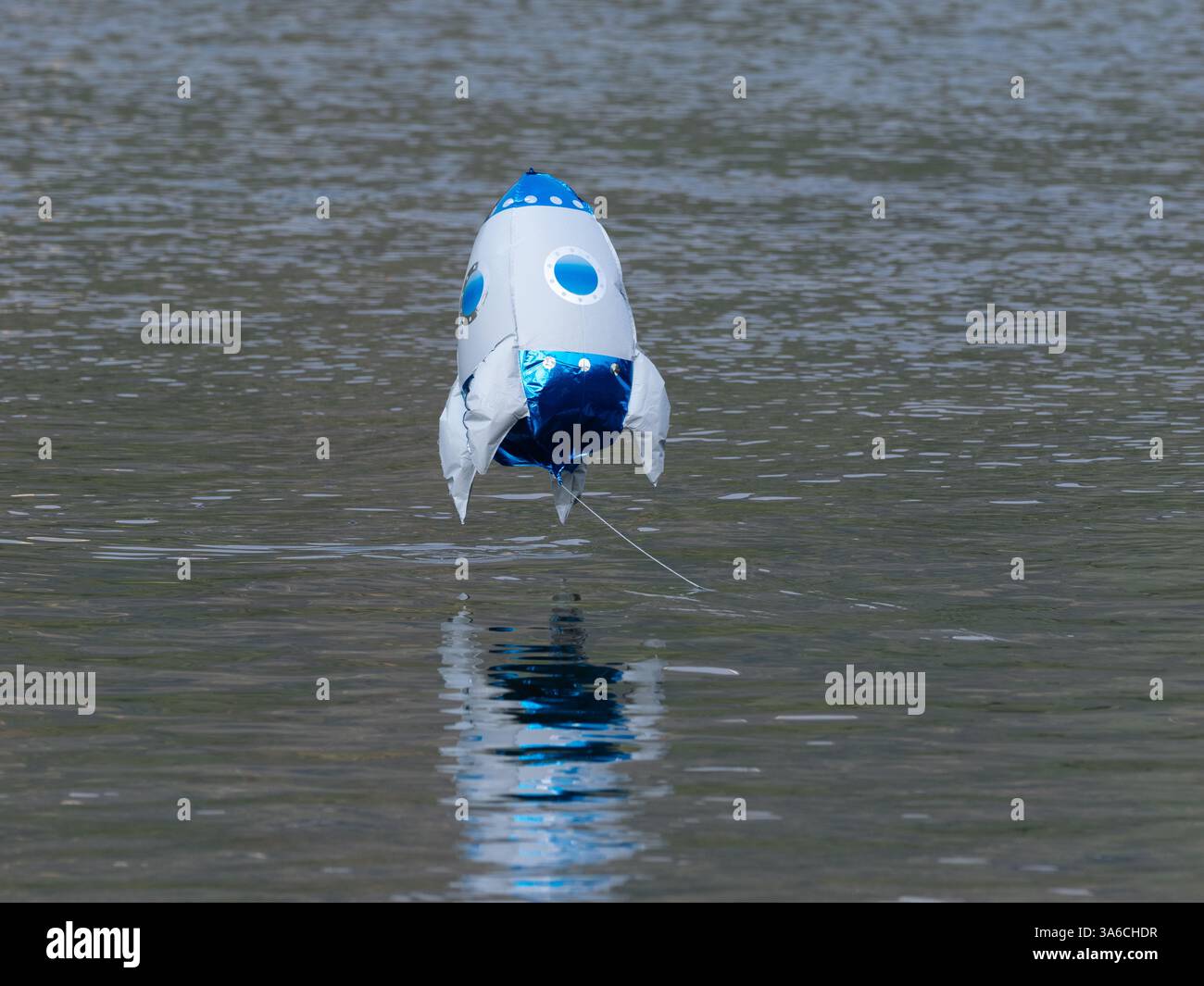 rocket shaped balloon landing on running water Stock Photo - Alamy