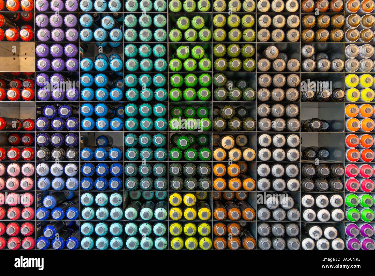Graffiti spray cans stacked and organized by color in a graffiti street ...