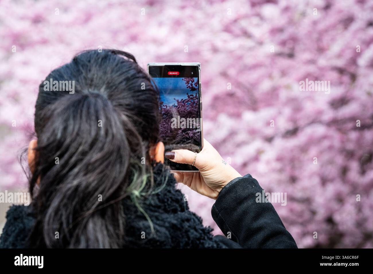London, UK. 25 March, 2025. A protester takes a photograph with a ...