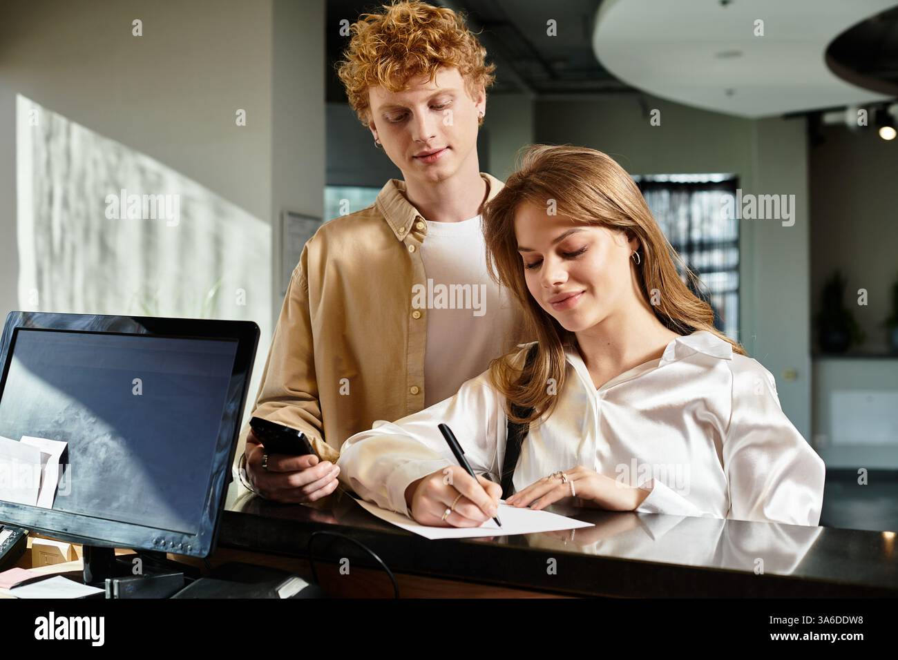 A beautiful couple shares a tender moment at the hotel front desk as ...