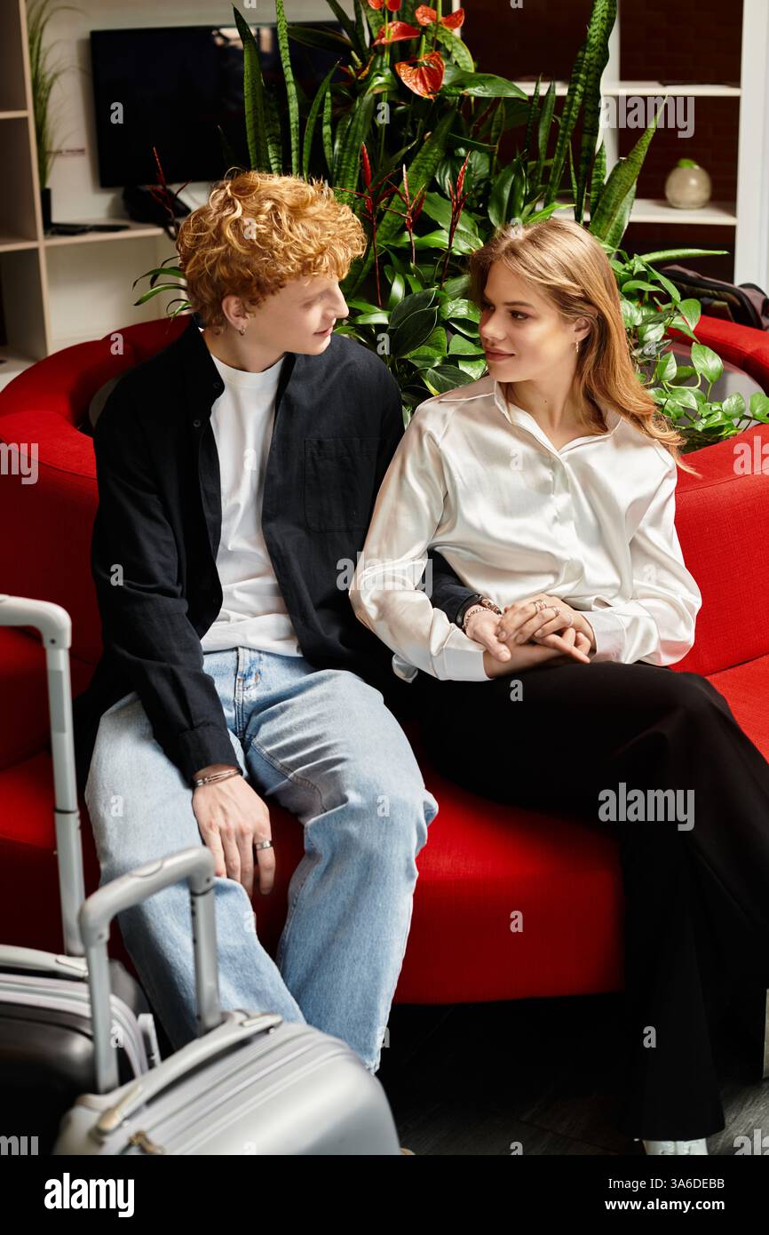 In a chic hotel lobby, a young couple shares a loving conversation ...
