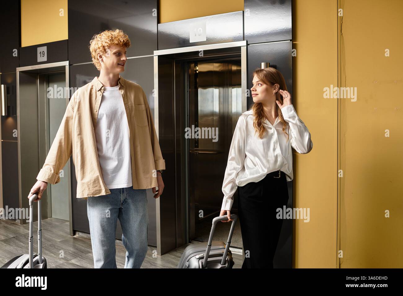 Loving couple stands in a stylish hotel hallway, sharing smiles while ...