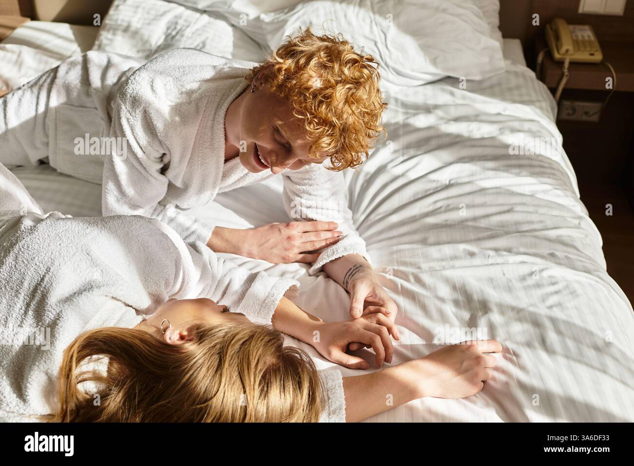 A young couple shares an intimate moment in a stylish hotel room with ...