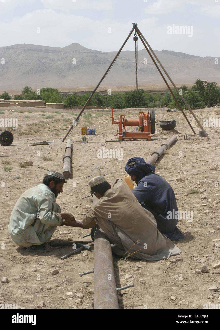May 14, 2004; FOB Payne, Afghanistan; Workers connect pipes that will ...