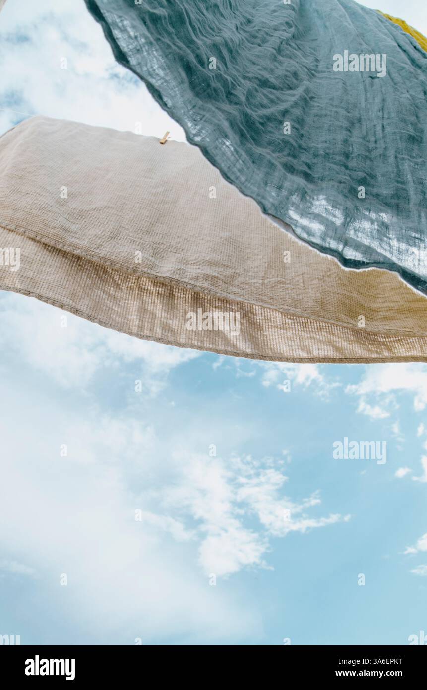 Low angle linens air drying on a clothesline with sky as background ...