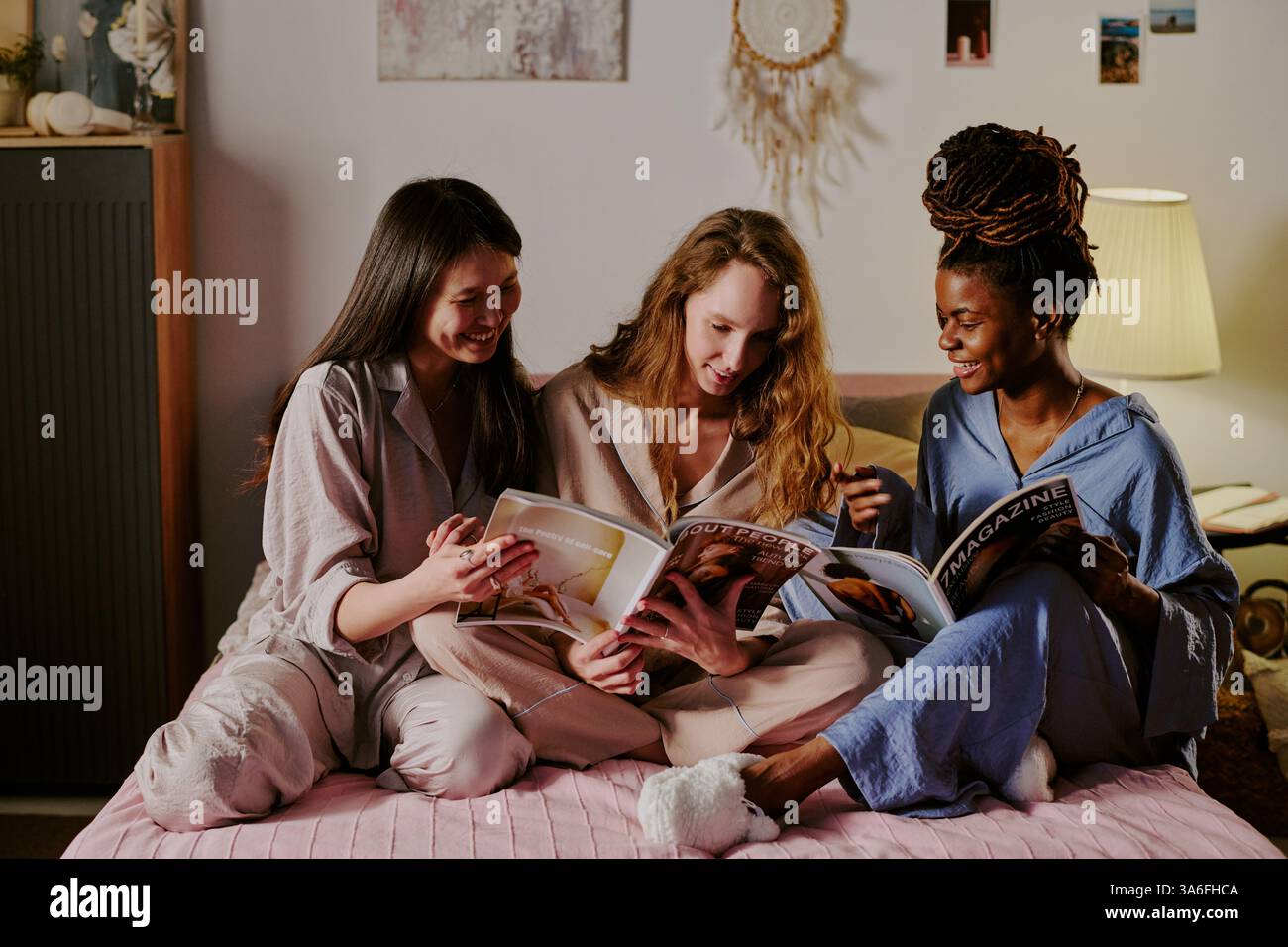Medium shot of biracial beautiful besties in stylish nightwear sitting ...