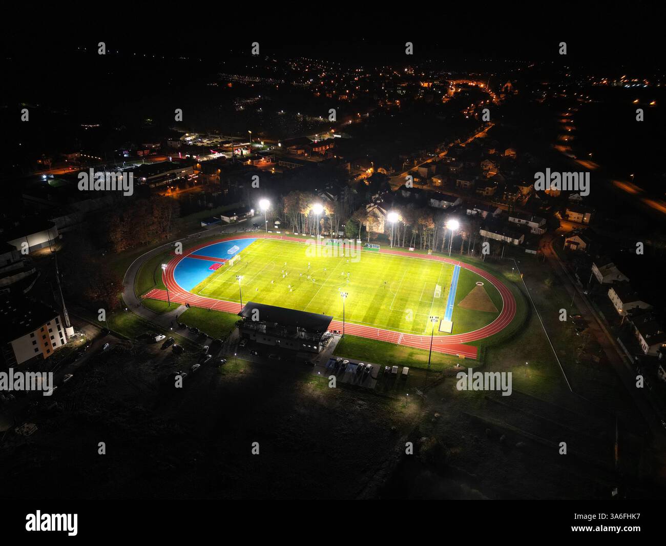 Aerial view of local football stadium at night, illuminated by ...