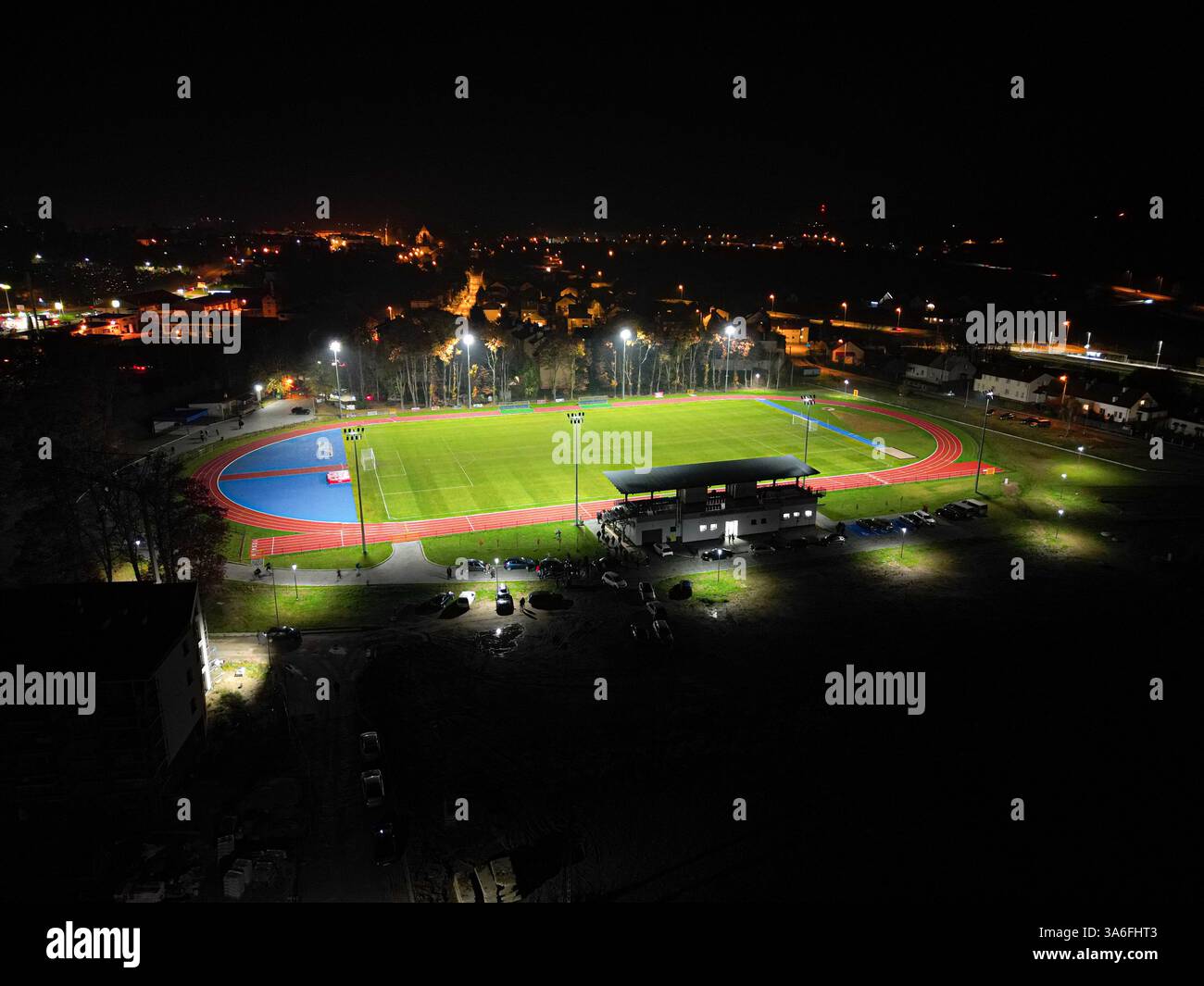 Aerial view of local football stadium at night, illuminated by ...