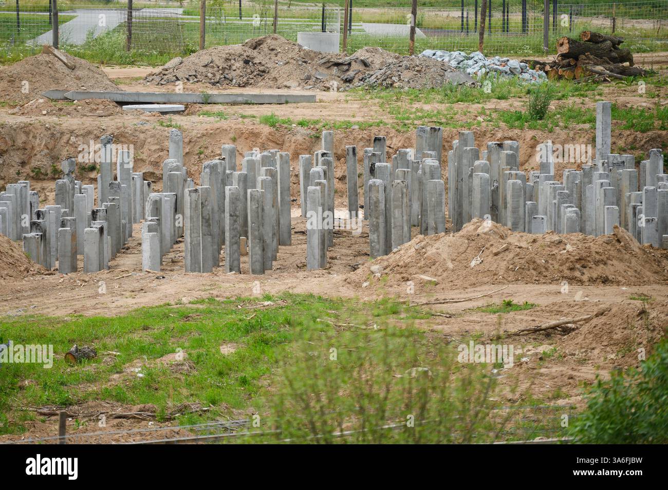 Reinforced concrete piles driven into pit at construction site. Driving ...