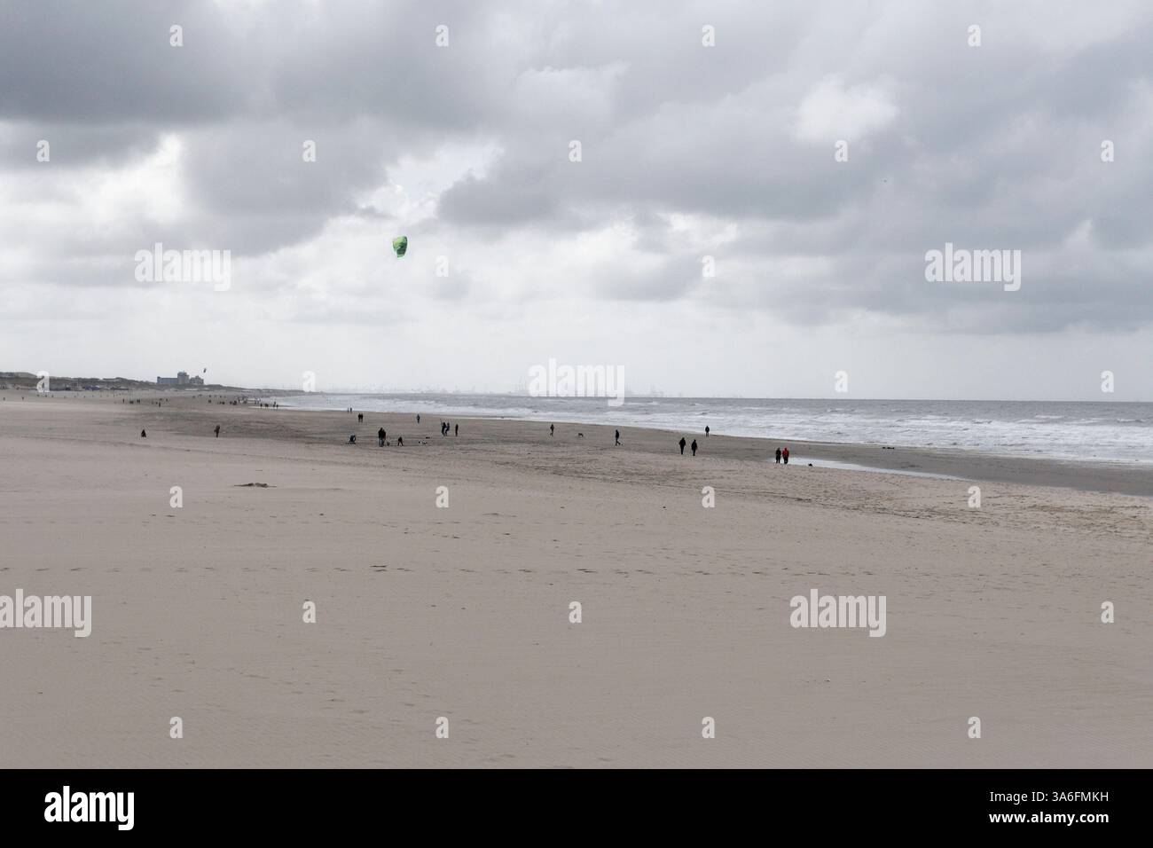 Sky with dramatic clouds with a wide, almost emtpy beach and dunes ...