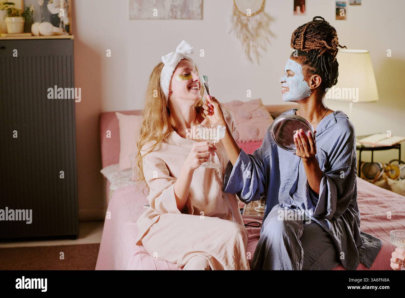 Medium shot of Caucasian and African American friends in pajamas ...