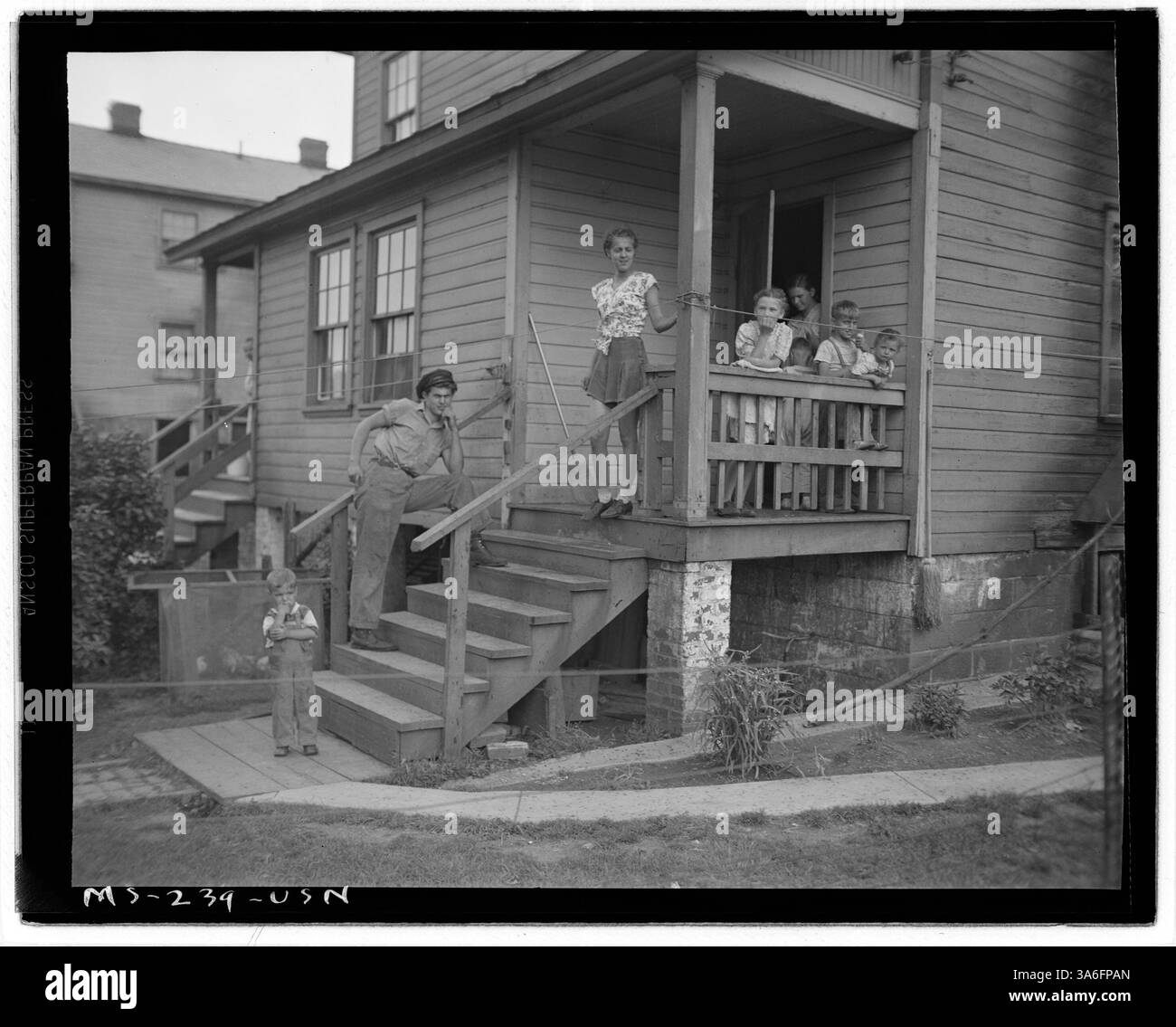 A miner’s family poses on the porch of their home within the company ...